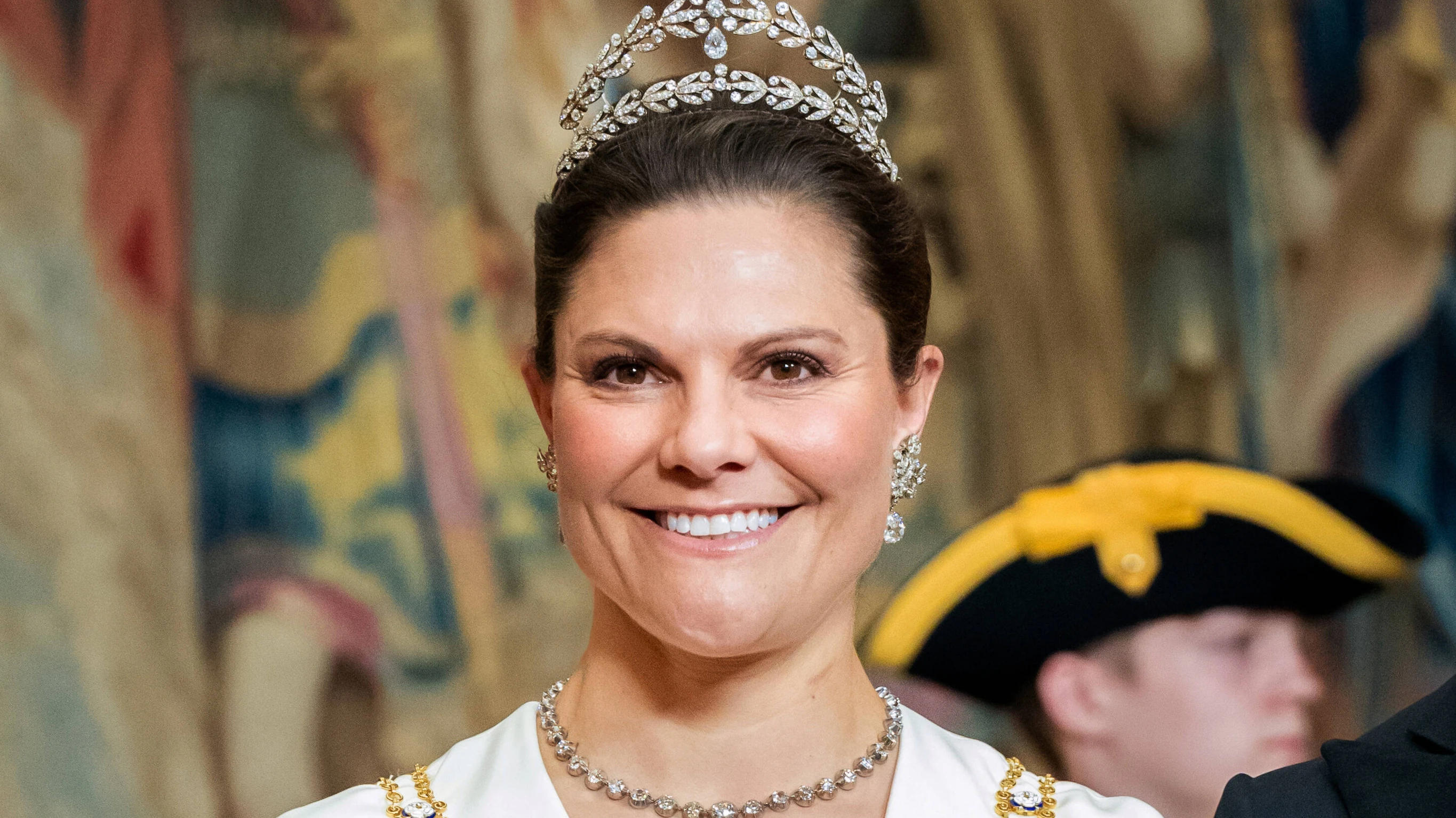 Kronprinsesse Victoria i hvid gallakjole med kappe og fjerdetaljer ...